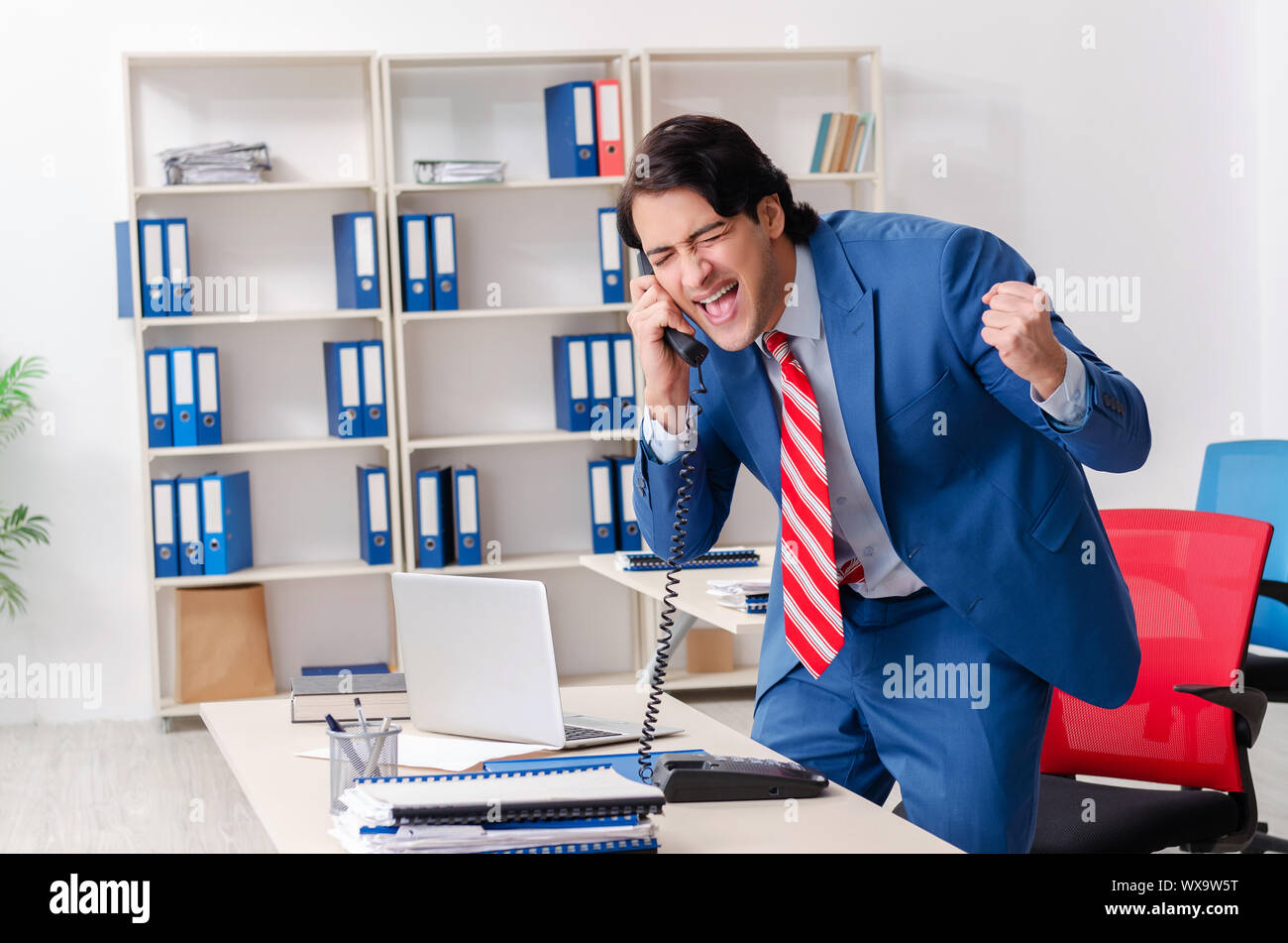 Young happy male employee in the office Stock Photo - Alamy