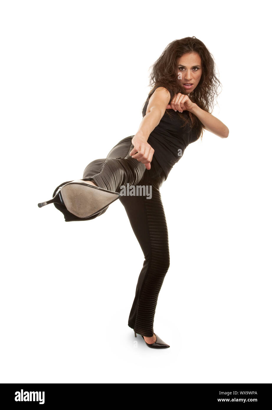 Tough woman in high heels kicking at camera Stock Photo - Alamy