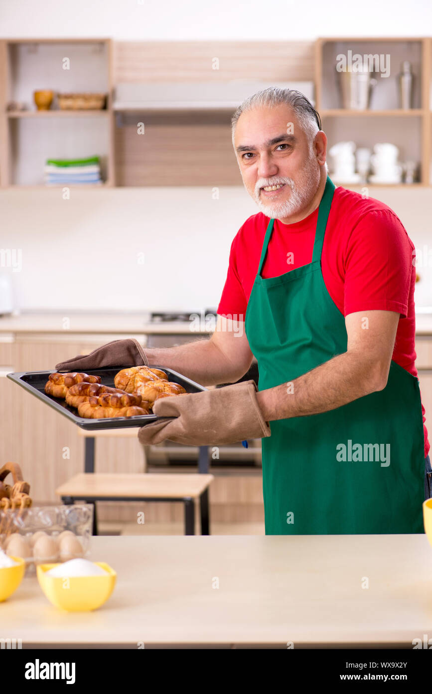 Old male baker working in the kitchen Stock Photo - Alamy