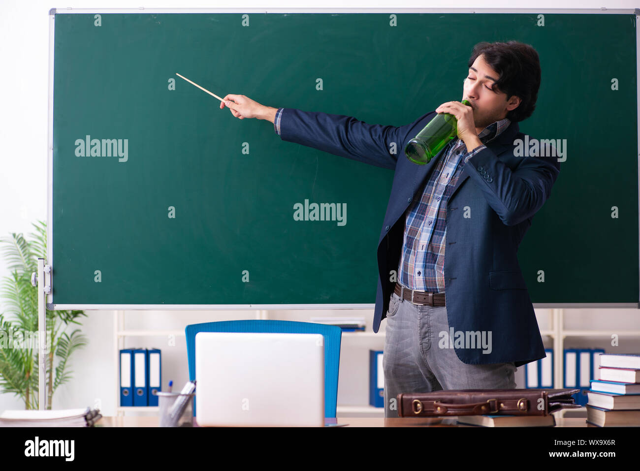 Male teacher drinking in the classroom Stock Photo - Alamy
