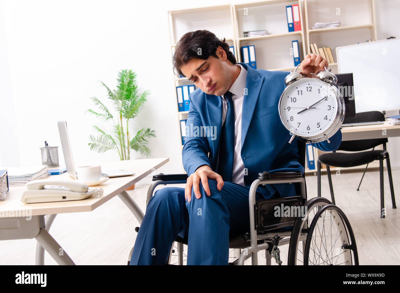 Male employee in wheelchair working at the office Stock Photo - Alamy