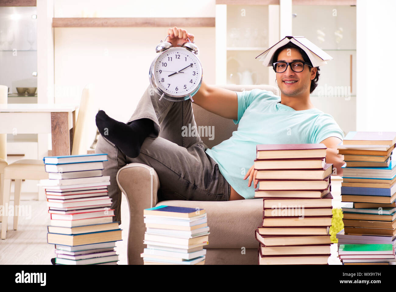 Male student with many books at home Stock Photo - Alamy