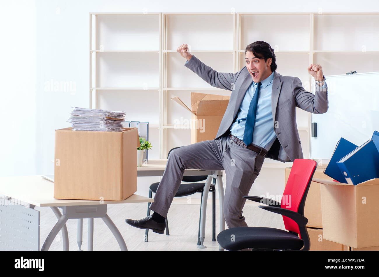 Young man employee with boxes in the office Stock Photo - Alamy