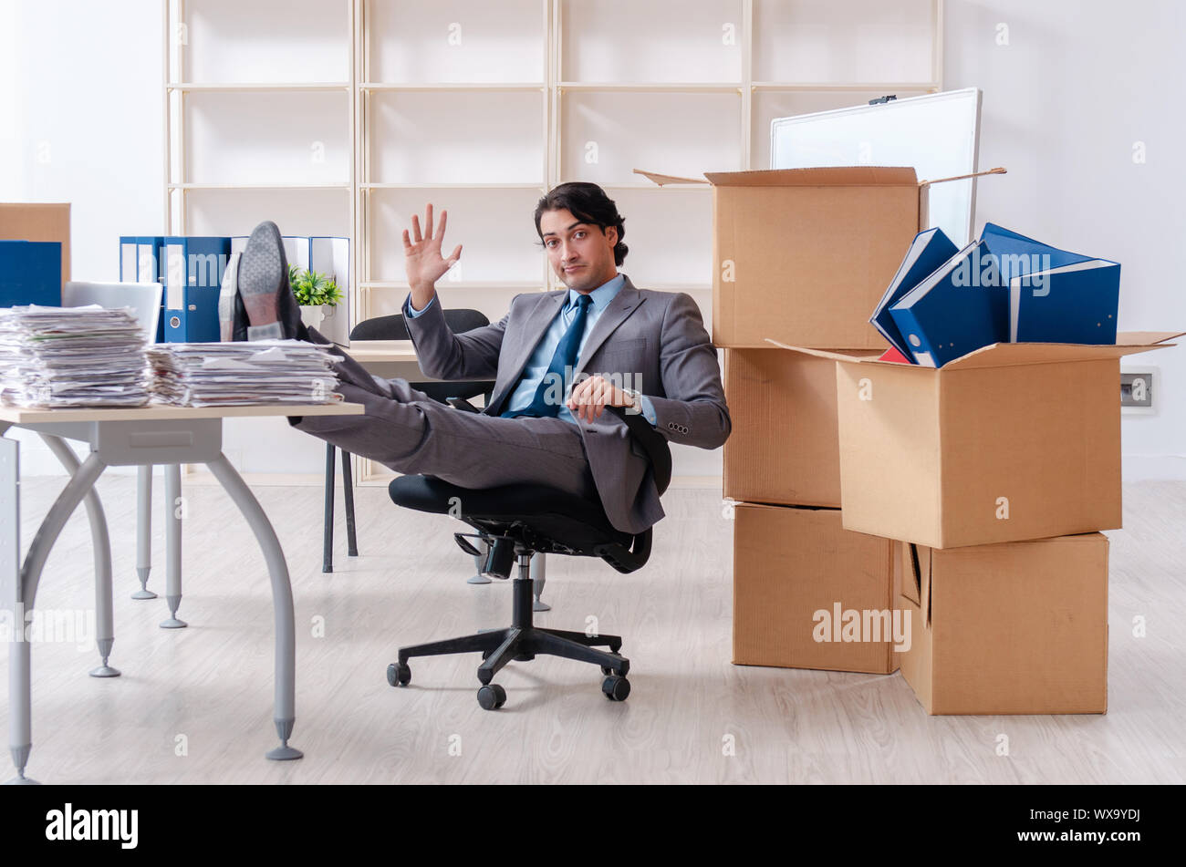 Young man employee with boxes in the office Stock Photo - Alamy