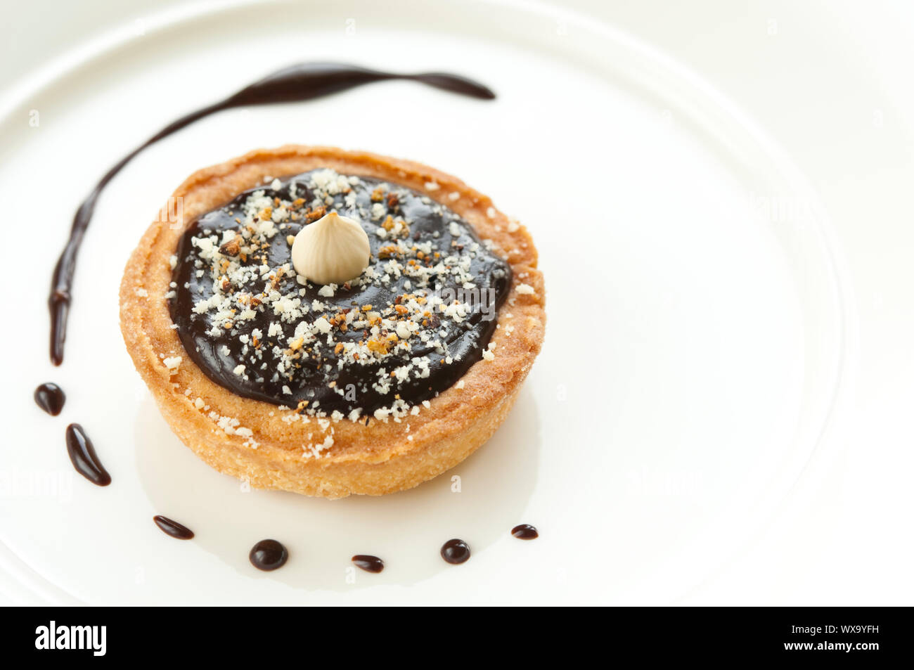 Mini chocolate tart with hazelnut on top Stock Photo - Alamy