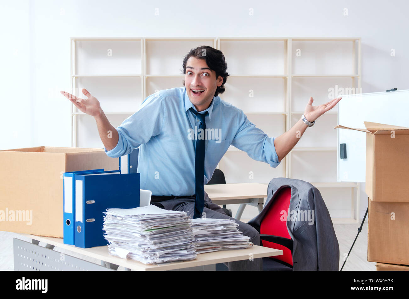 Young man employee with boxes in the office Stock Photo - Alamy