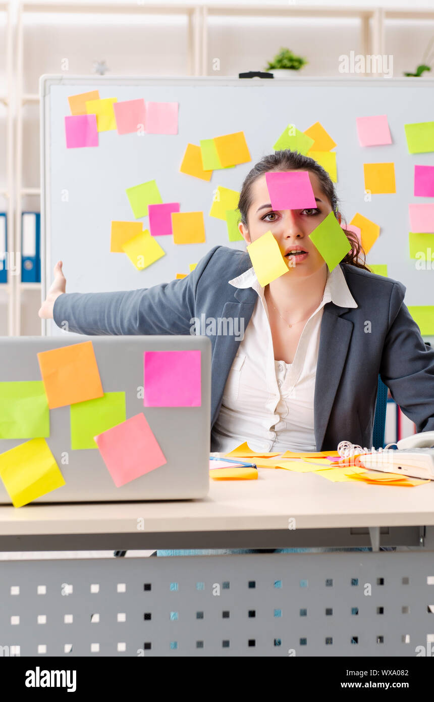 Young female employee in conflicting priorities concept Stock Photo - Alamy