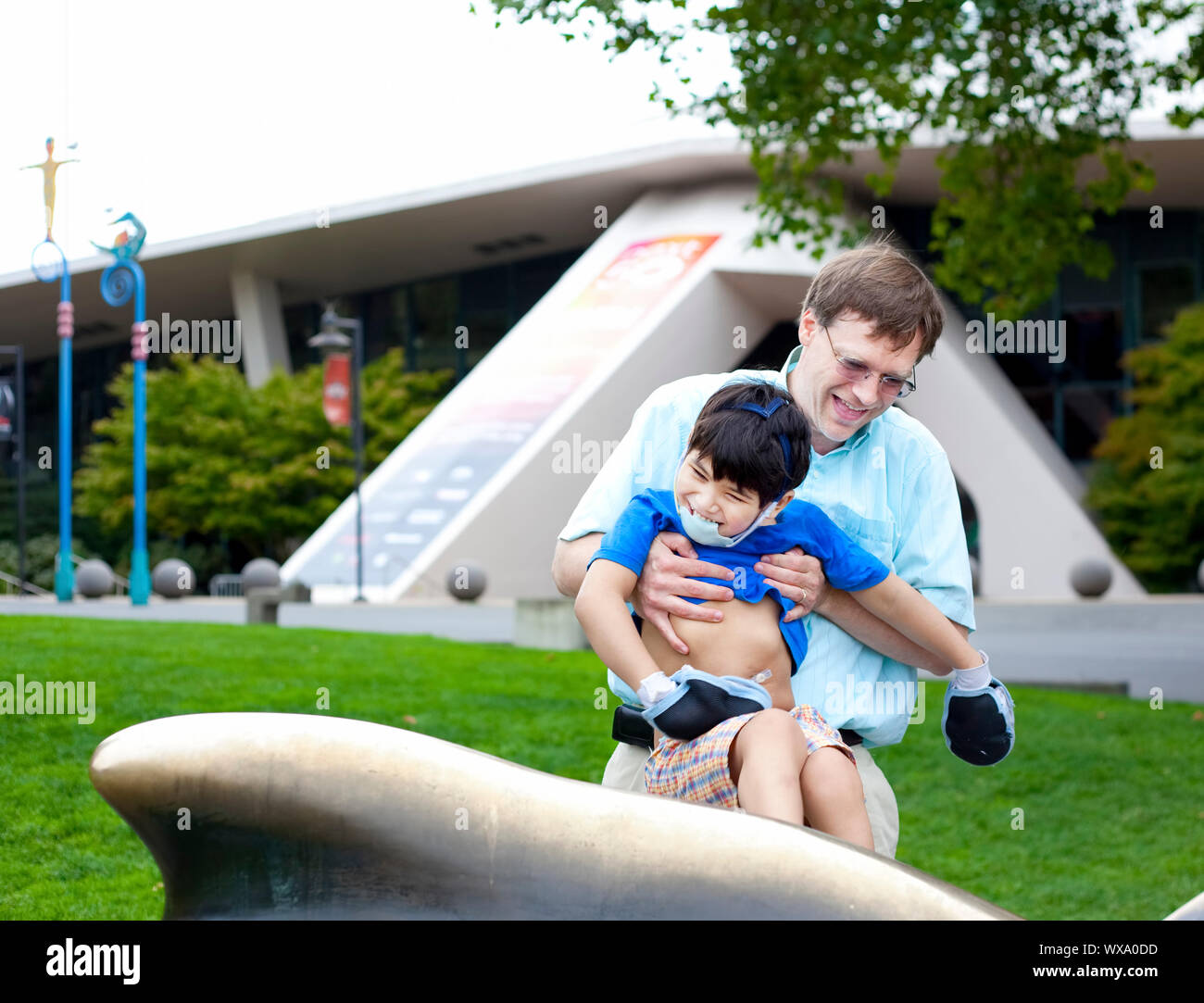 Father helping disabled son play outdoors Stock Photo - Alamy