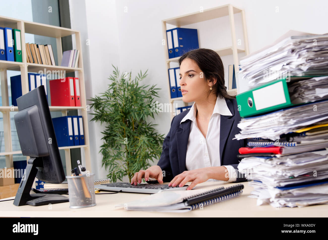 Female employee with too much work in the office Stock Photo - Alamy