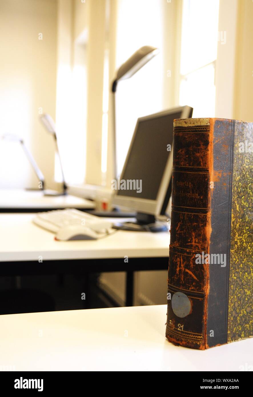 old books and computer on a desk in a library Stock Photo - Alamy