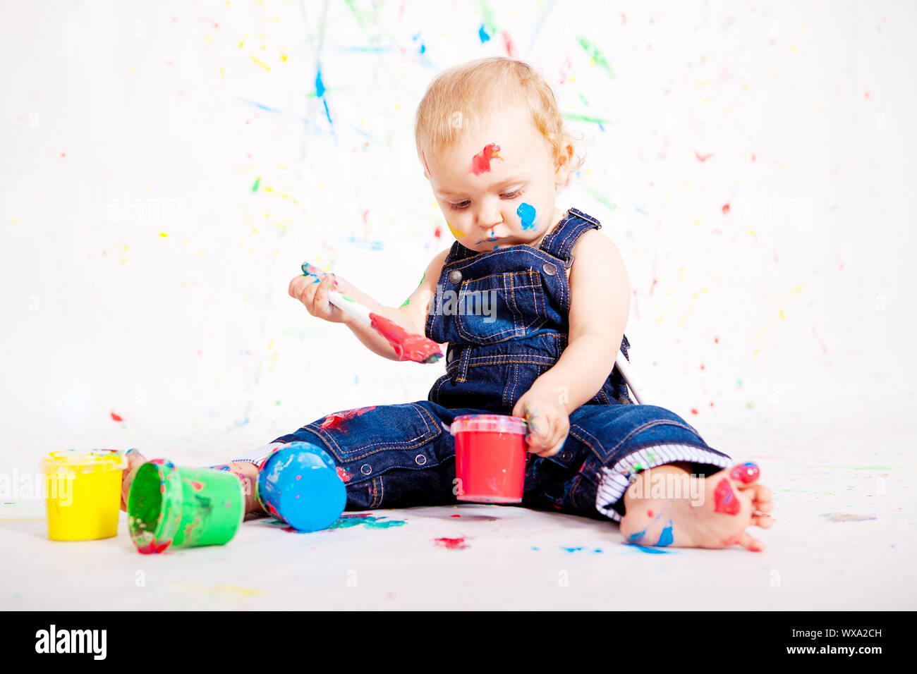 cute little baby painting and splatter with colours creativity on white ...