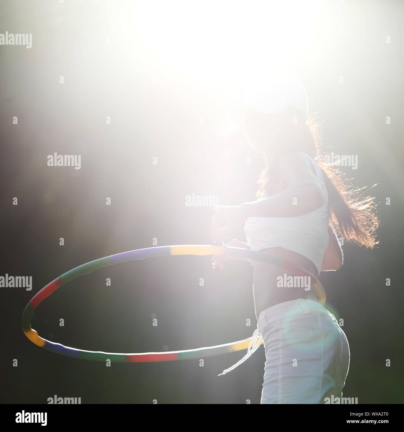 woman rotates hula hoop on nature background Stock Photo - Alamy