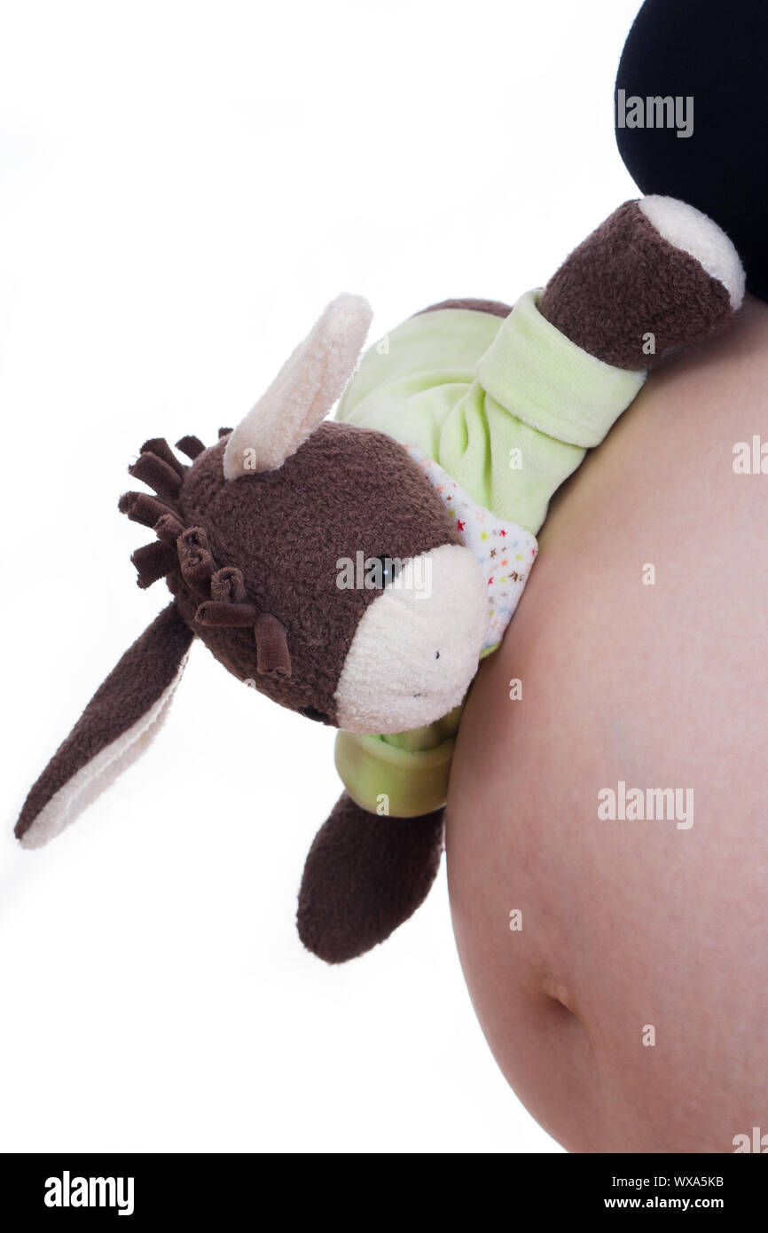 Pregnant girl showing her belly and holding a toy Stock Photo - Alamy