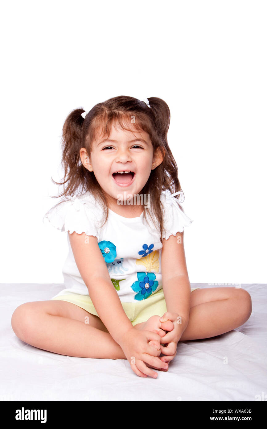 Cute happy smiling laughing toddler girl sitting on bed Stock Photo - Alamy