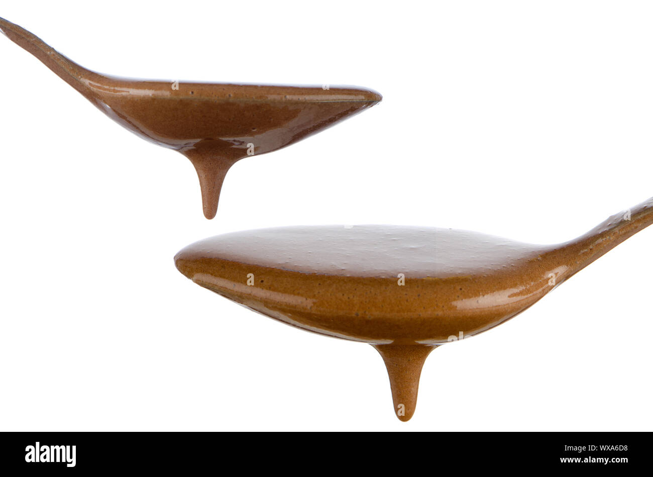 Liquid Chocolate dripping from two spoons on white background Stock ...