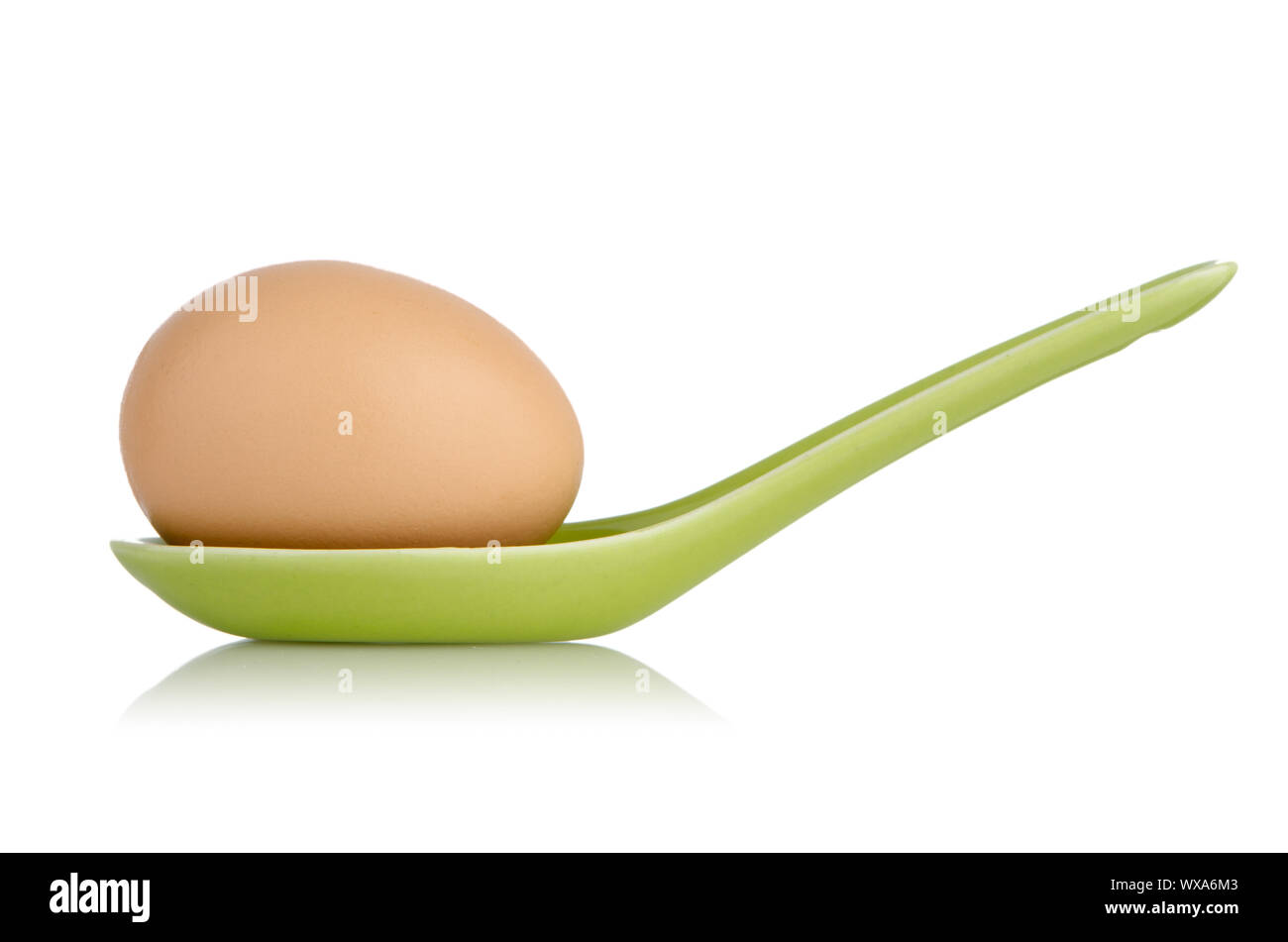Brown egg in a green ceramic spoon isolated on white background Stock ...