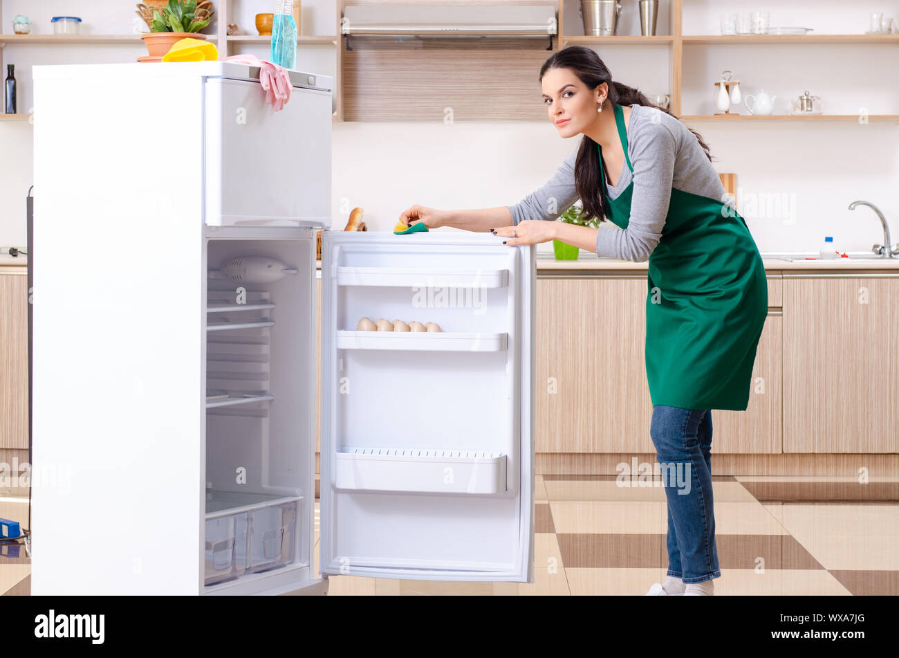 Young woman cleaning fridge in hygiene concept Stock Photo - Alamy