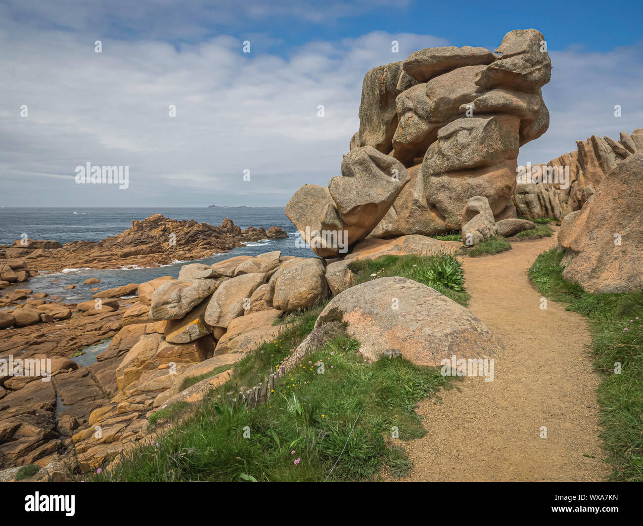 Path between giant boulders above the craggy rocks above the sea along ...