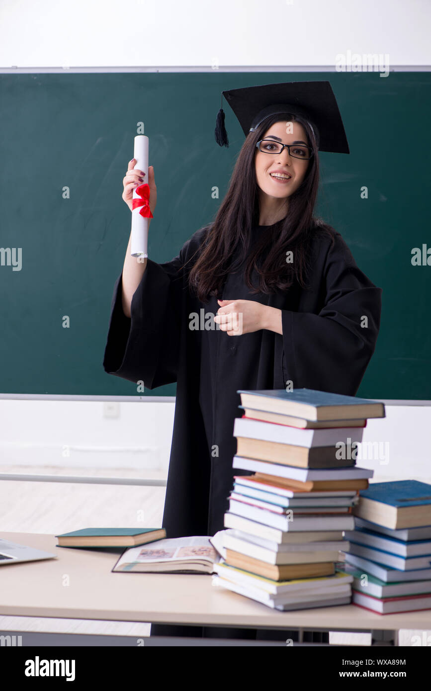 Female graduate student in front of green board Stock Photo - Alamy