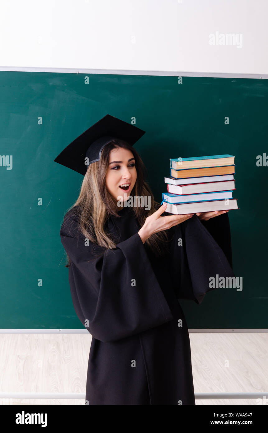 Female graduate student in front of green board Stock Photo - Alamy