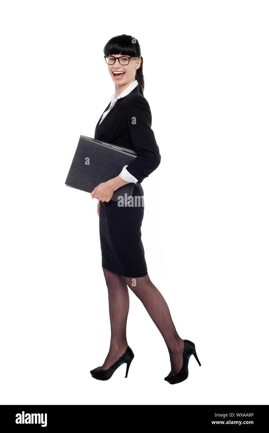 Cheerful smart business lady walking with files in her hands. Studio ...