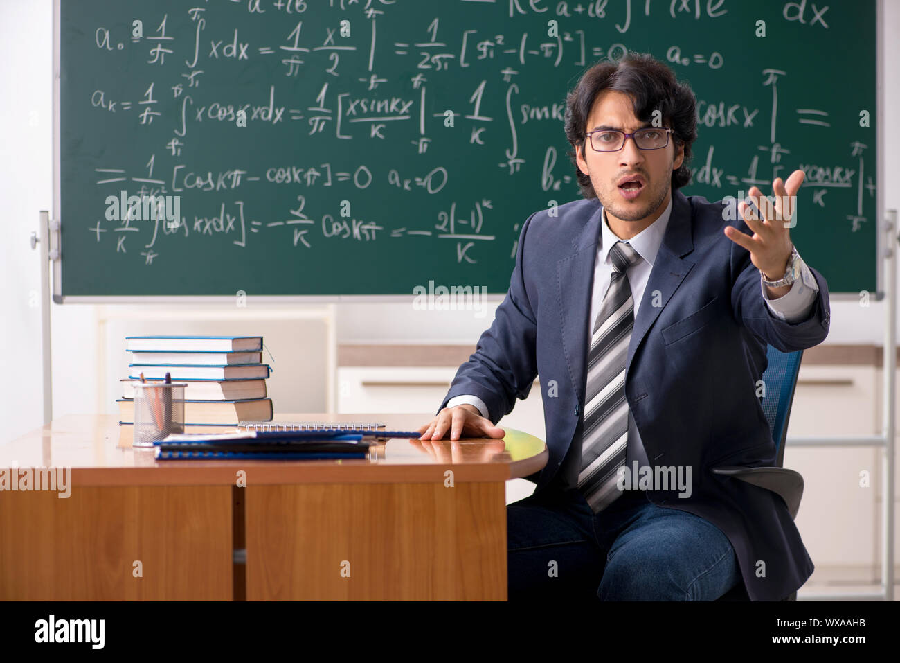 Young male math teacher in classroom Stock Photo - Alamy