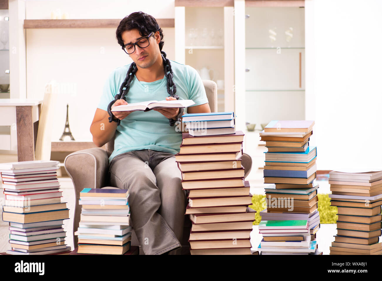 Male student with many books at home Stock Photo - Alamy