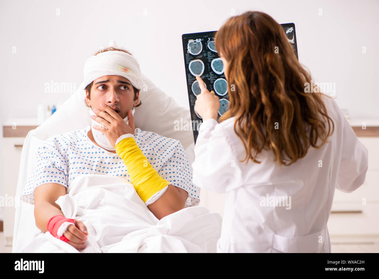 Young doctor examining injured patient Stock Photo - Alamy