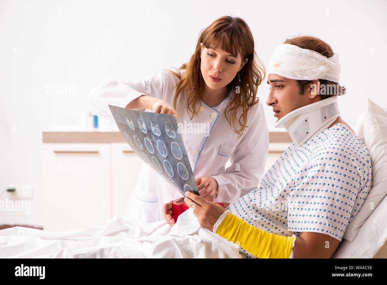 Young doctor examining injured patient Stock Photo - Alamy