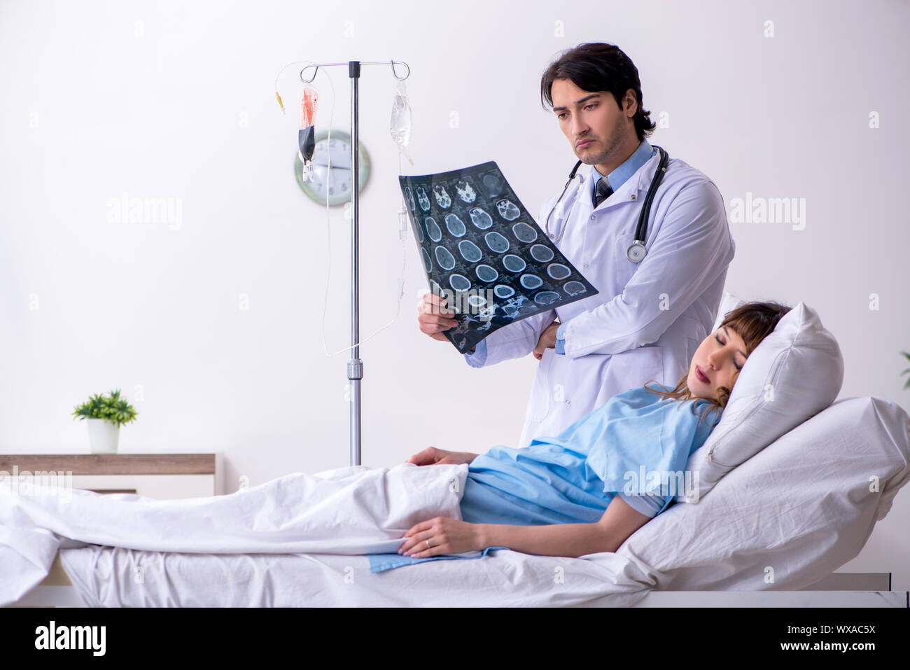 Male doctor visiting female patient in ward Stock Photo - Alamy