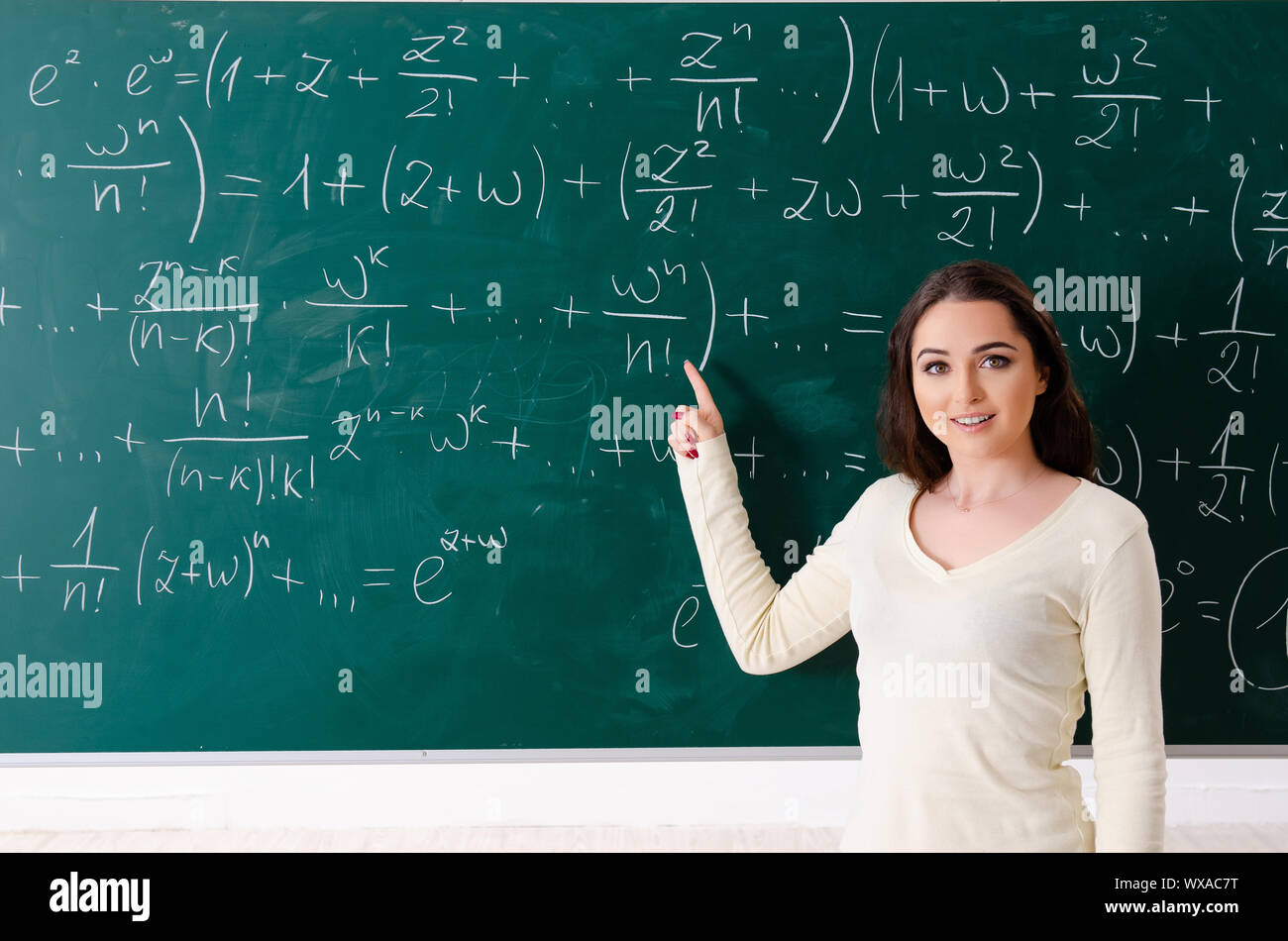 Young female math teacher in front of chalkboard Stock Photo - Alamy