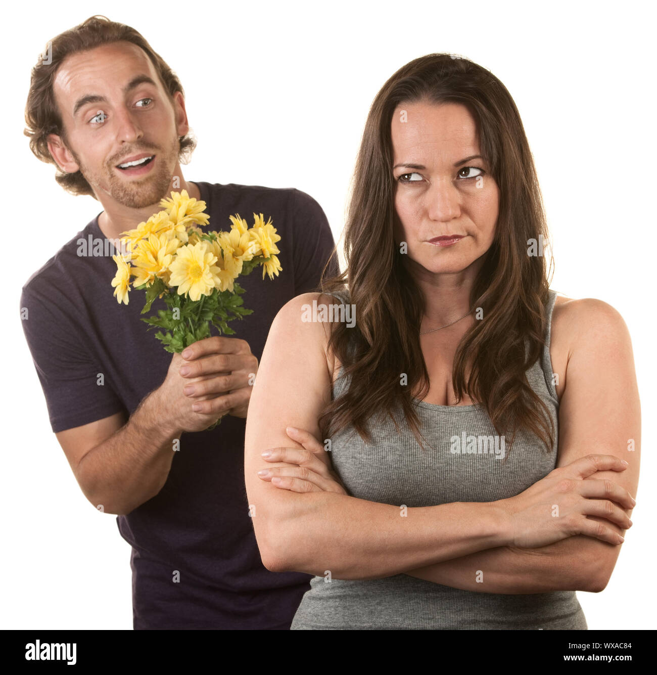 Skeptical female with smiling young man holding flowers Stock Photo - Alamy
