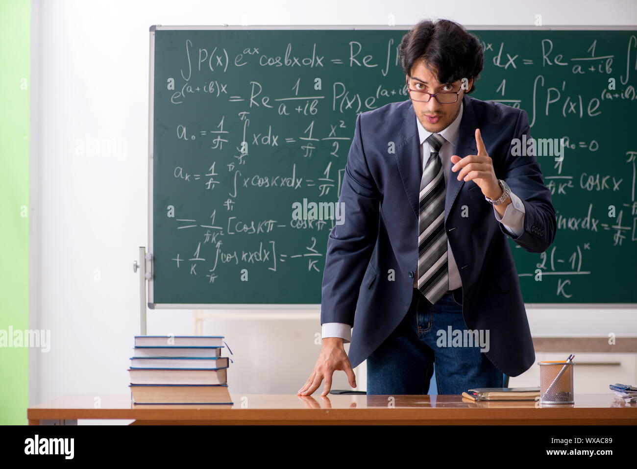 Young male math teacher in classroom Stock Photo - Alamy
