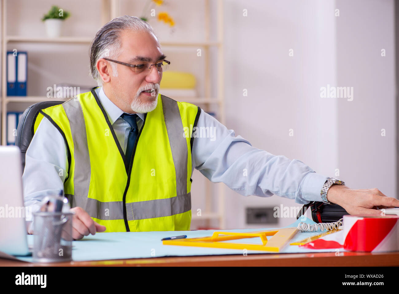 Aged construction engineer working in the office Stock Photo - Alamy