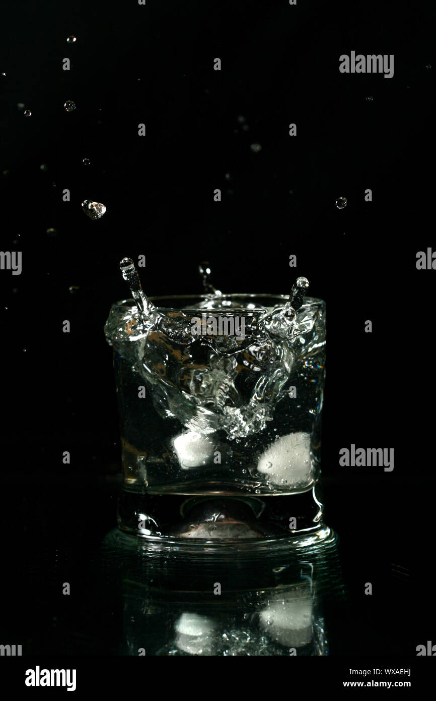 alcohol splash on black background close up Stock Photo - Alamy