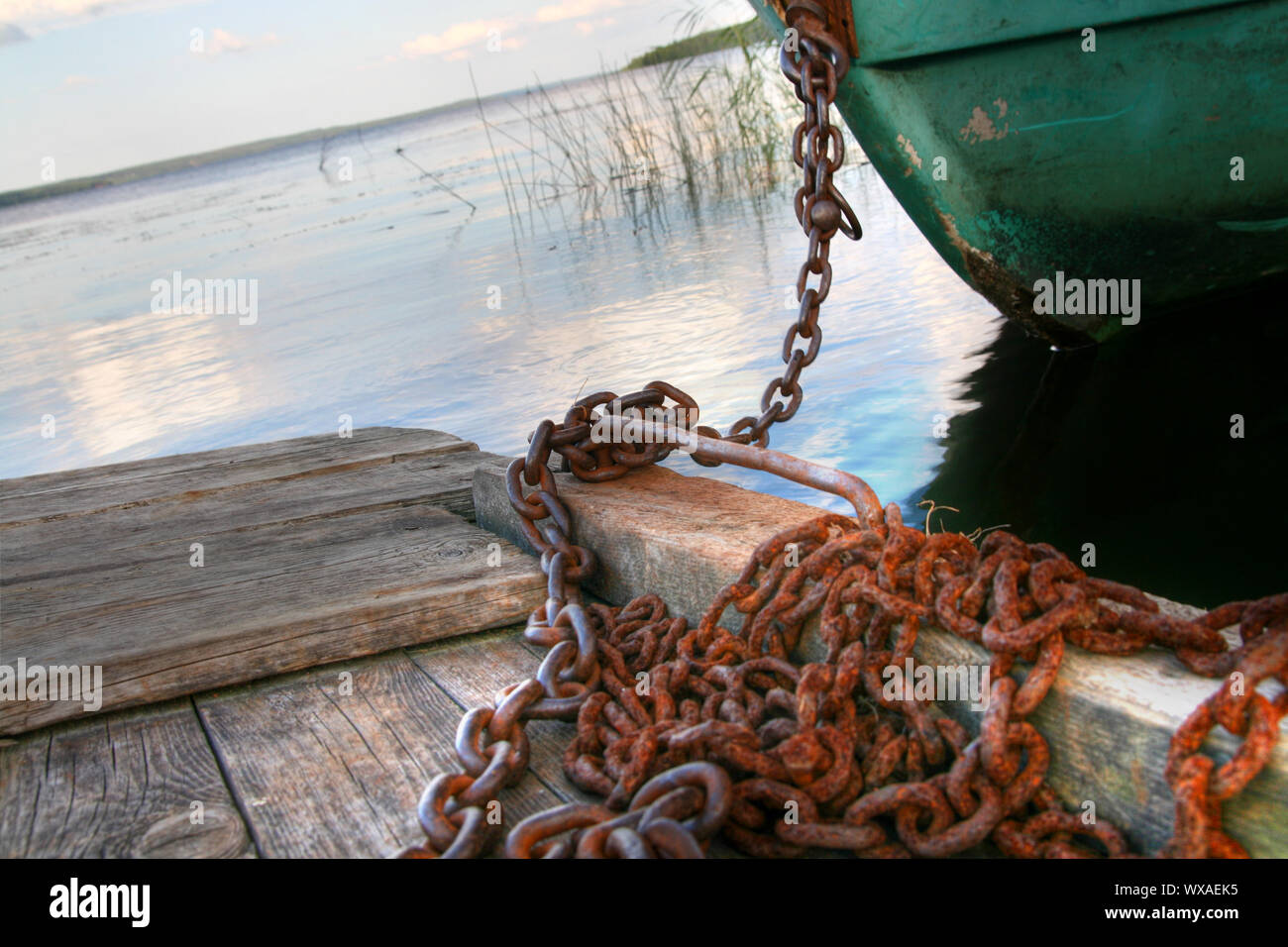 boat on old chain in water Stock Photo - Alamy