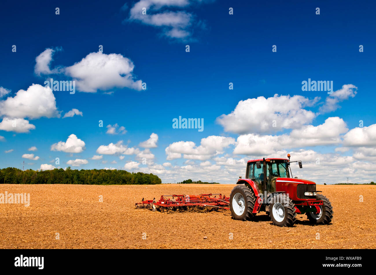 Small scale farming with tractor and plow in field Stock Photo - Alamy