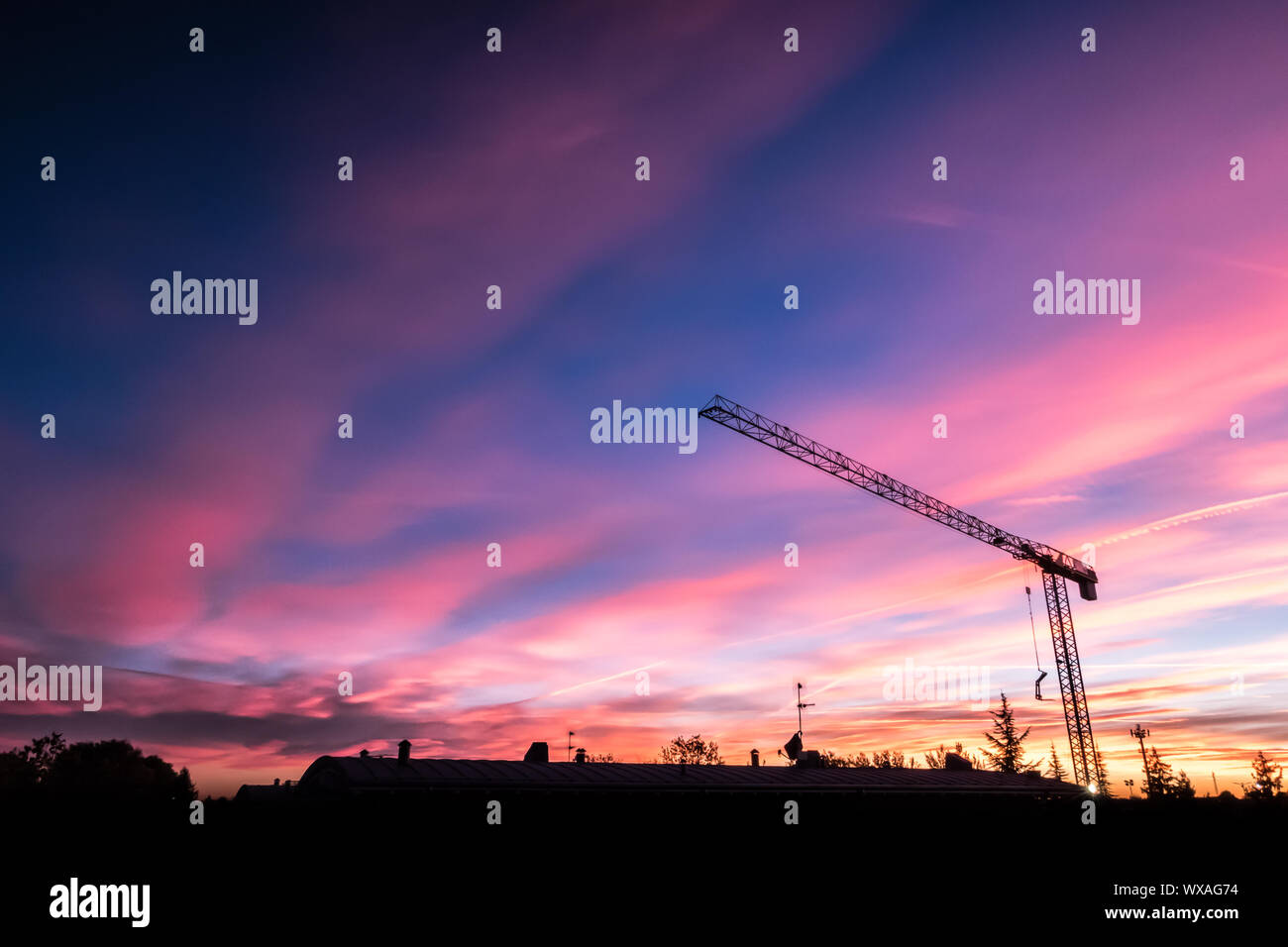 Construction crane over sunset sky Stock Photo - Alamy