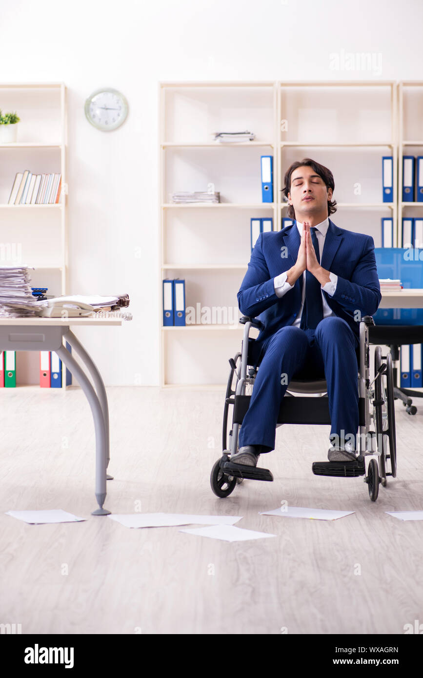 Young male employee in wheelchair working in the office Stock Photo - Alamy