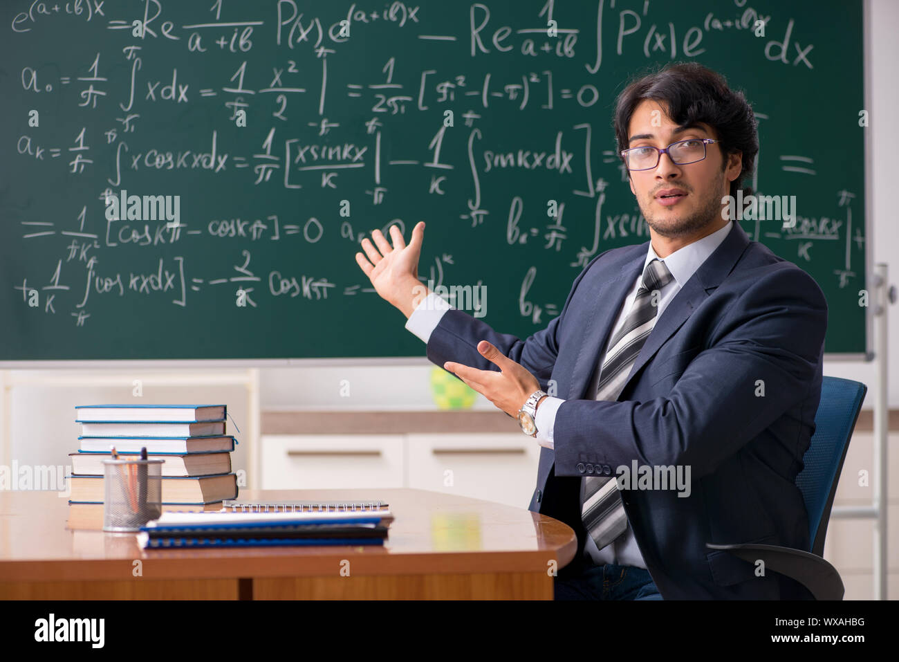 Young male math teacher in classroom Stock Photo - Alamy