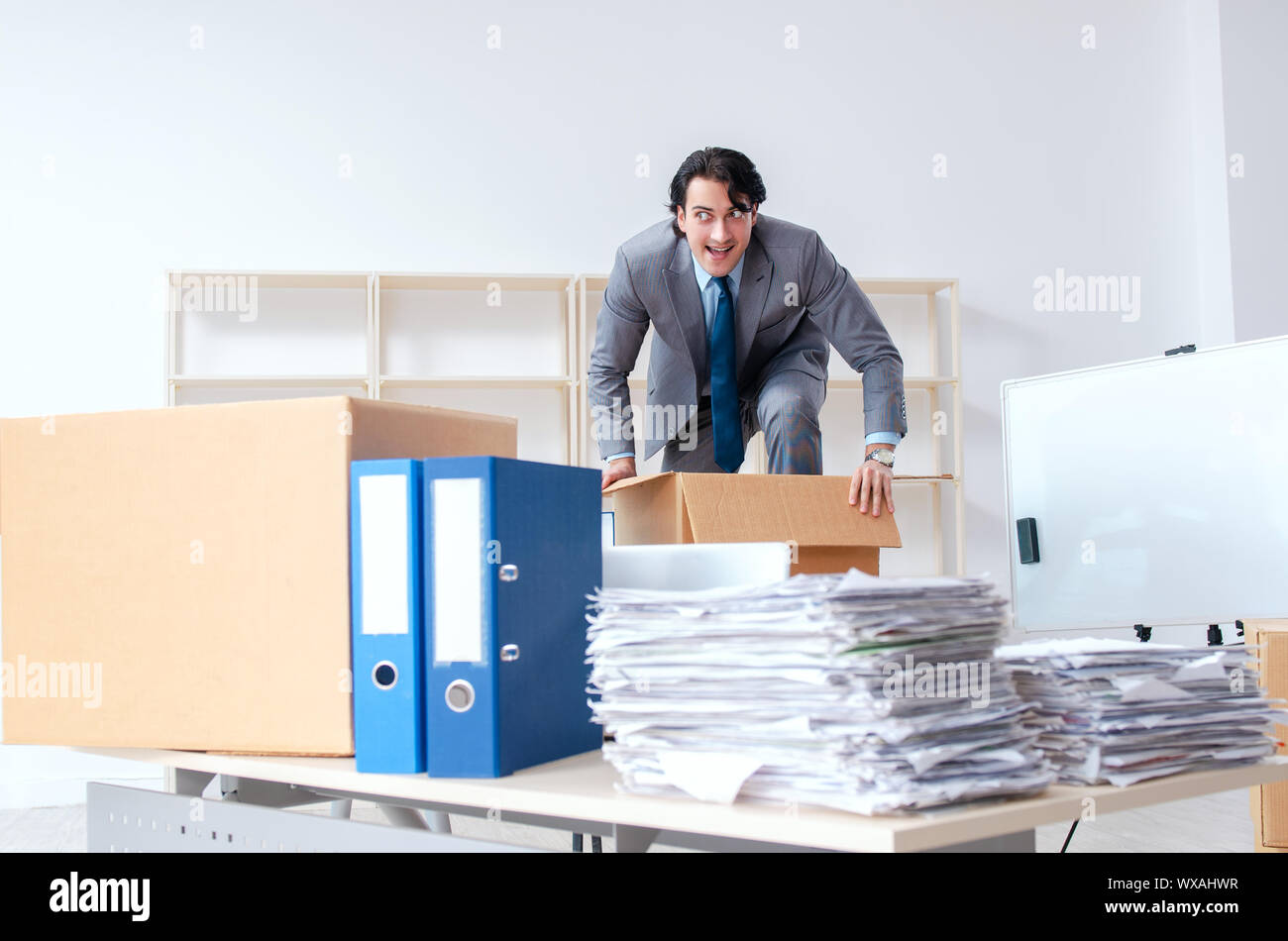 Young man employee with boxes in the office Stock Photo - Alamy