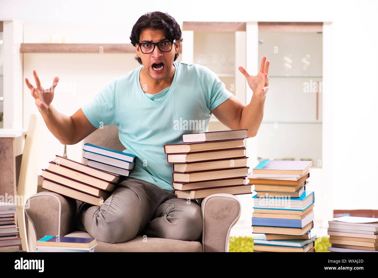 Male student with many books at home Stock Photo - Alamy