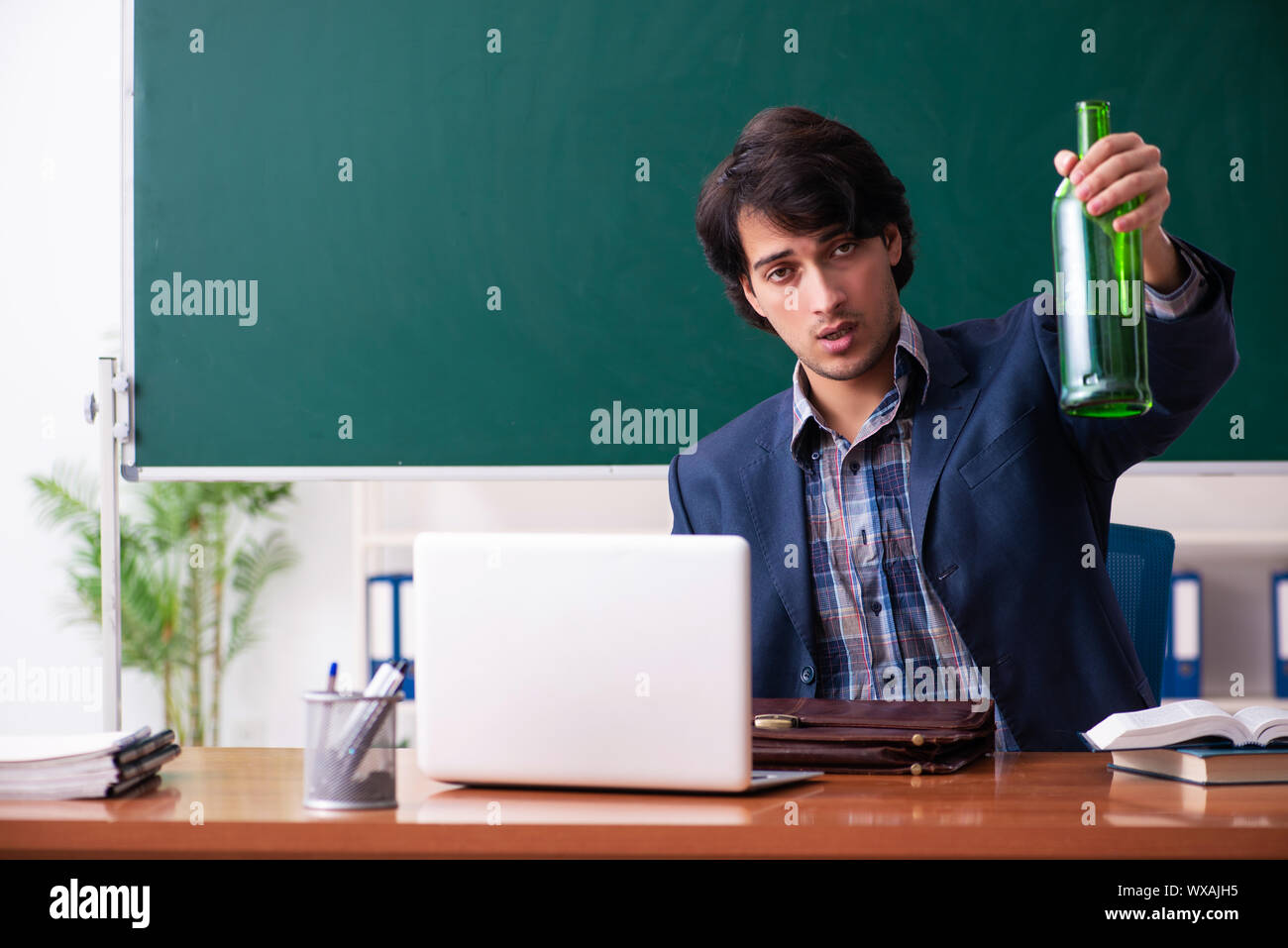 Male teacher drinking in the classroom Stock Photo - Alamy