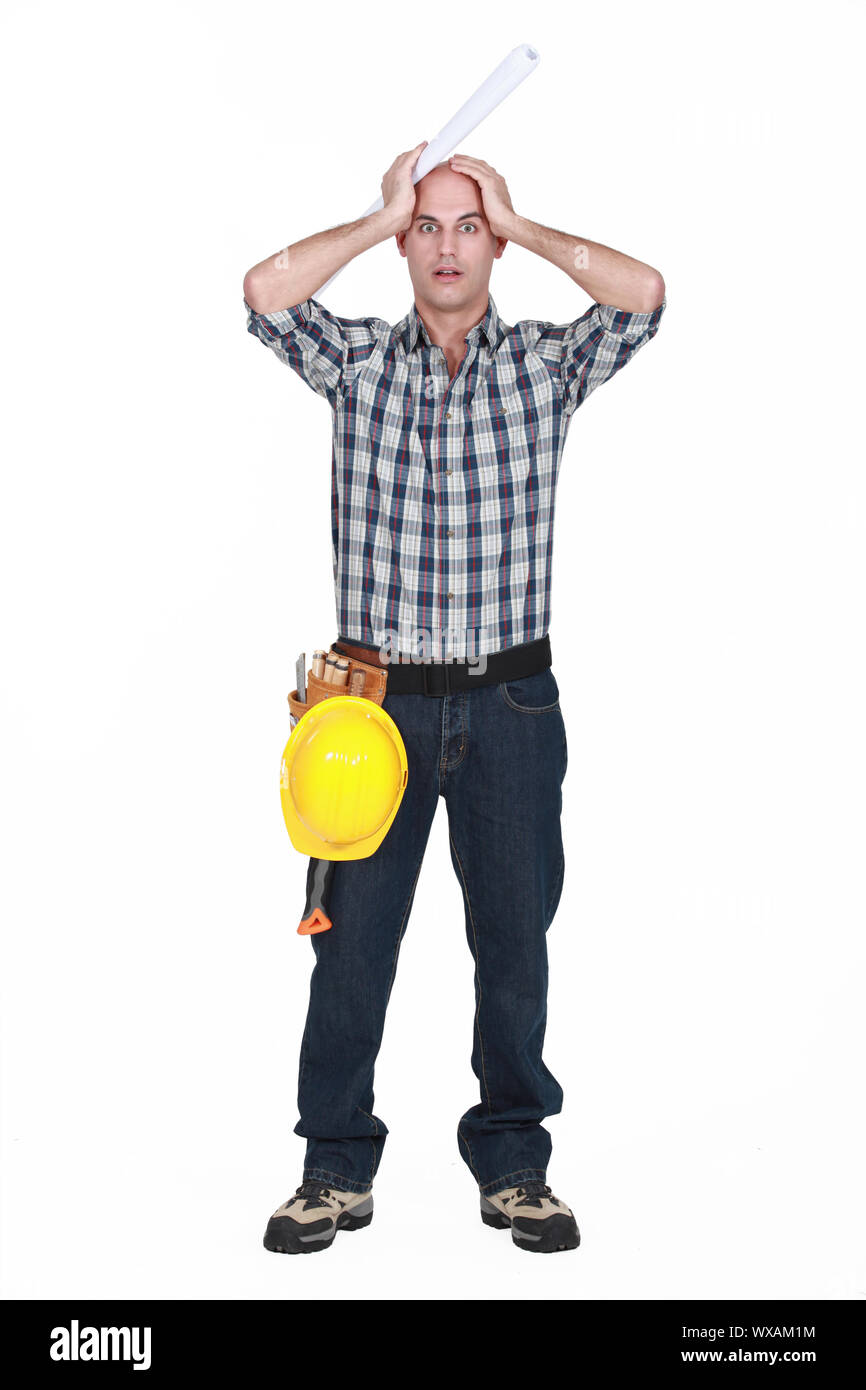 Construction worker holding his head in horror Stock Photo - Alamy