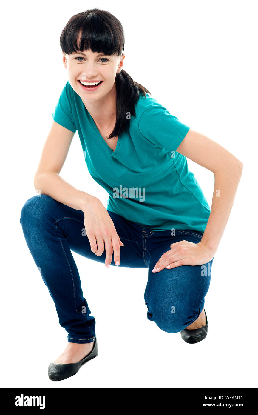 Good looking female model in squatting posture. Casual studio shot ...