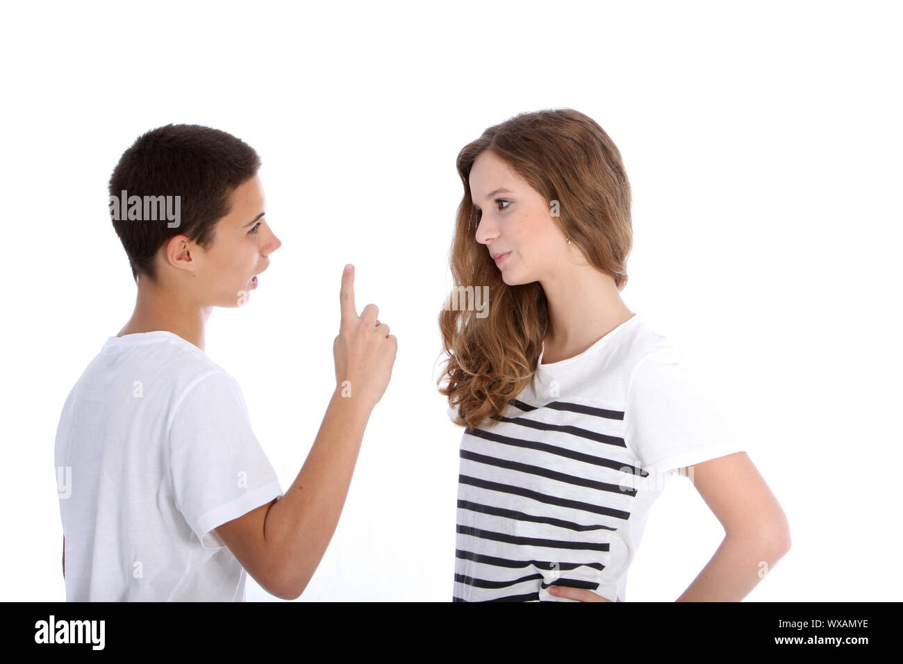 Two young teenagers arguing with the boy wagging his finger at his ...