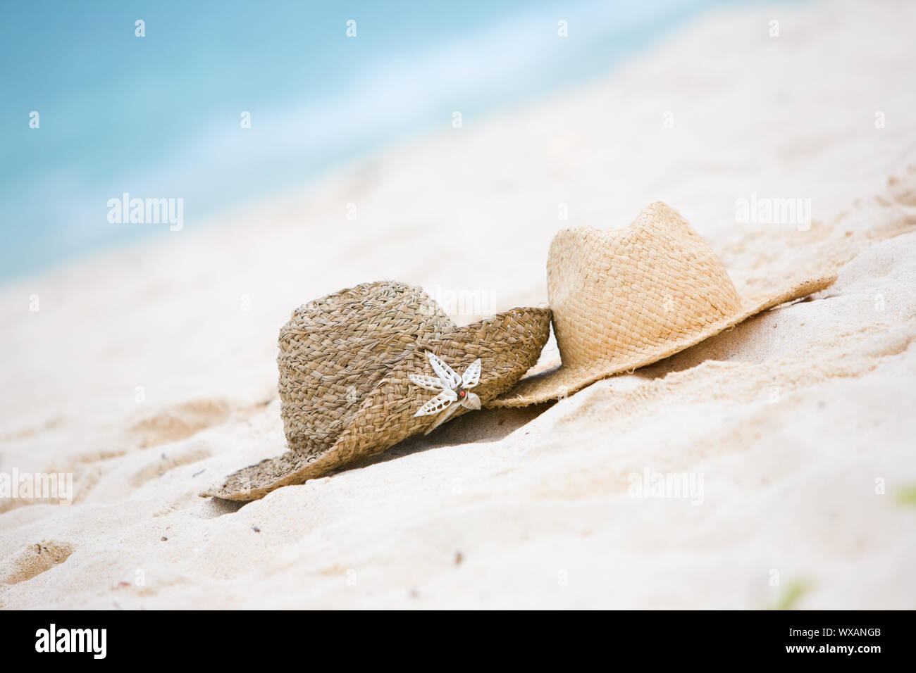 Two straw hats on white sand tropical beach Stock Photo - Alamy