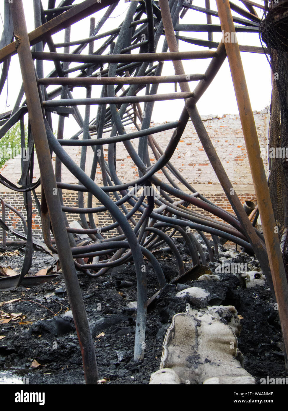 Twisted steel beams after a factory fire. Warehouse destroyed by fire ...