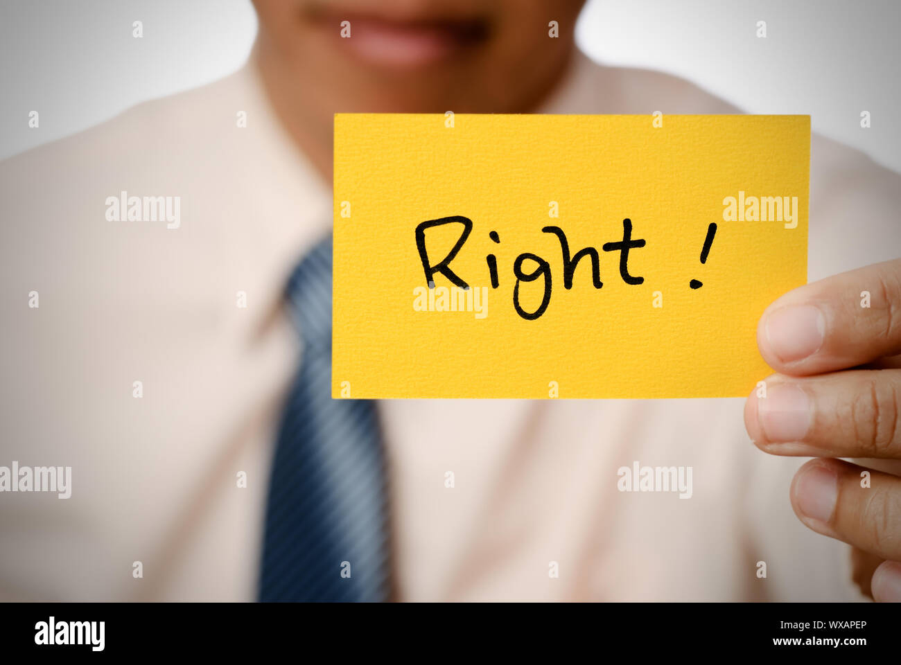 Right words card in yellow holding by businessman Stock Photo - Alamy