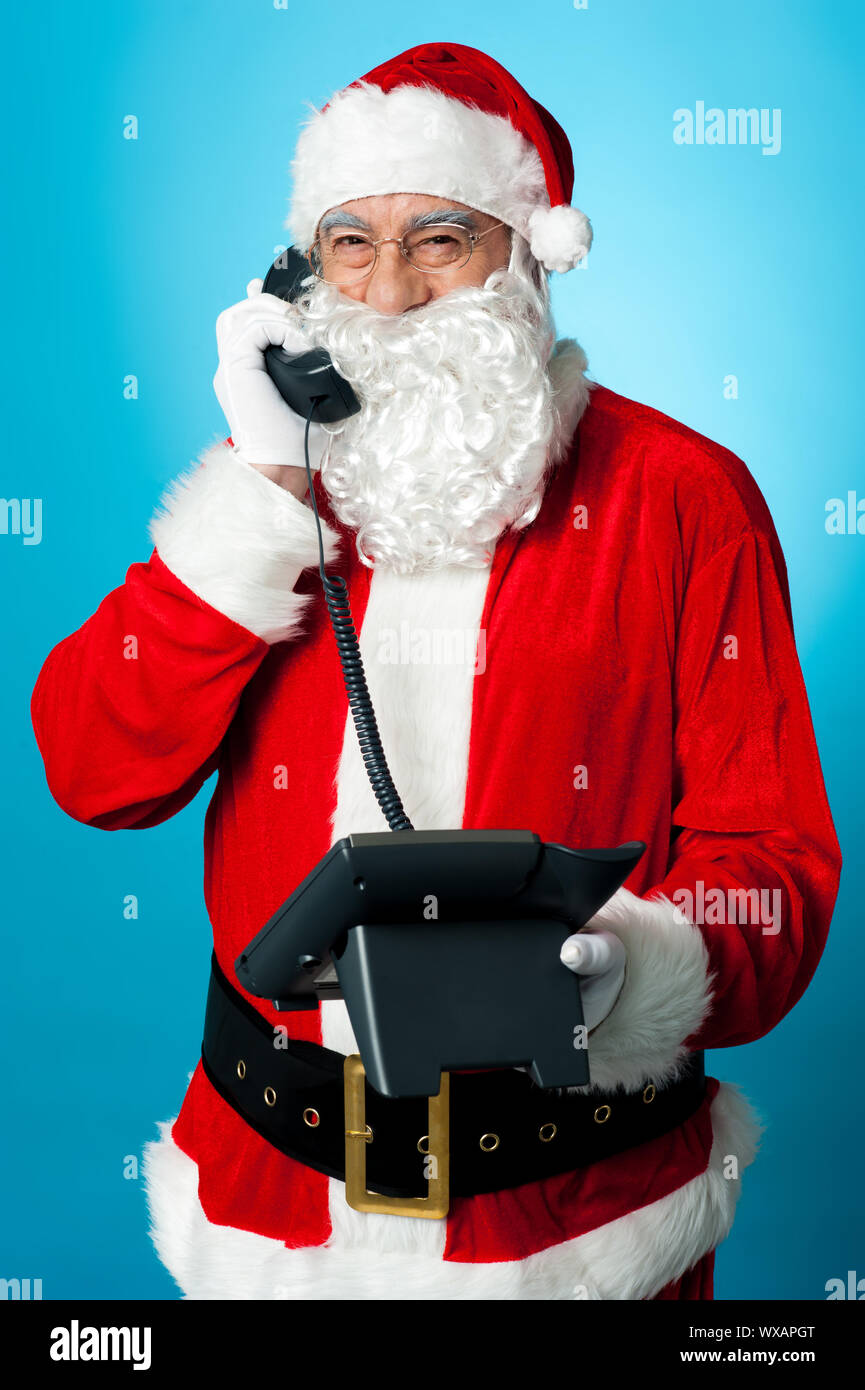 Modern Santa passing greetings over a phone call isolated against blue ...